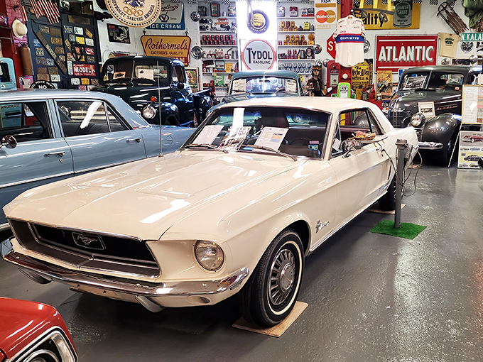 A classic car gleams under vintage signs asking "When did you lubricate last?" The answer: whenever Detroit still made them this beautiful.