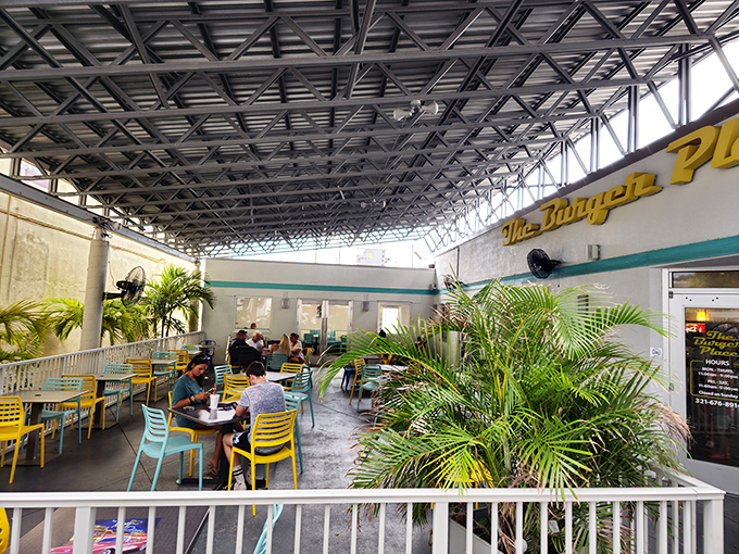 The covered outdoor seating area at The Burger Place offers a tropical Florida oasis where palm fronds and good conversation flourish alongside great food.
