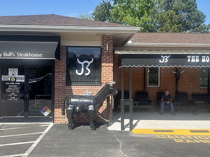 The unassuming brick exterior of Johnny Bull's Steakhouse, complete with its iconic bull statue, proves that culinary greatness doesn't need flashy packaging.