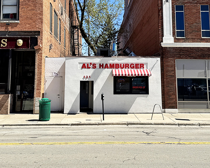The unassuming white facade of Al's Hamburger in Green Bay might not scream "culinary landmark," but that red-striped awning is practically a bat signal for burger lovers.