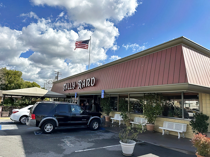 The American flag waves proudly above Tallyrand's classic red and cream exterior, where white benches await hungry patrons like front-row seats to breakfast nirvana.