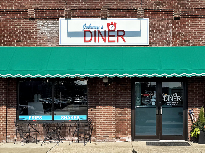 The unassuming brick exterior of Johnny's Diner in Hudson might not scream "culinary destination," but that green awning signals delicious secrets await inside.