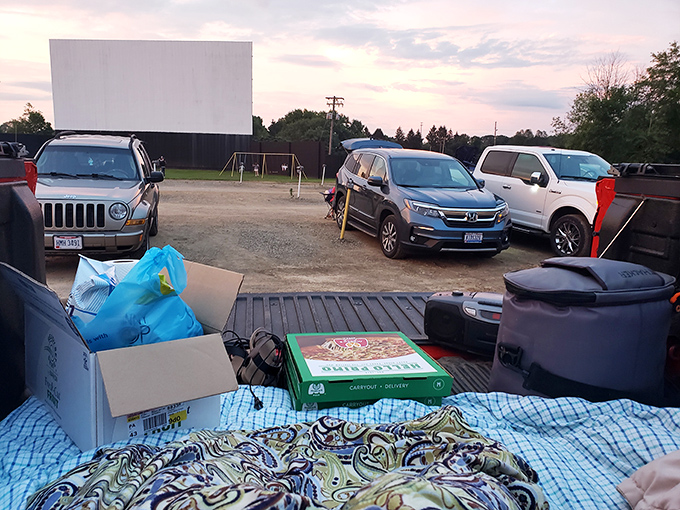 The massive white screen at Magic City Drive-In stands ready for showtime, a blank canvas awaiting cinematic magic as dusk approaches.