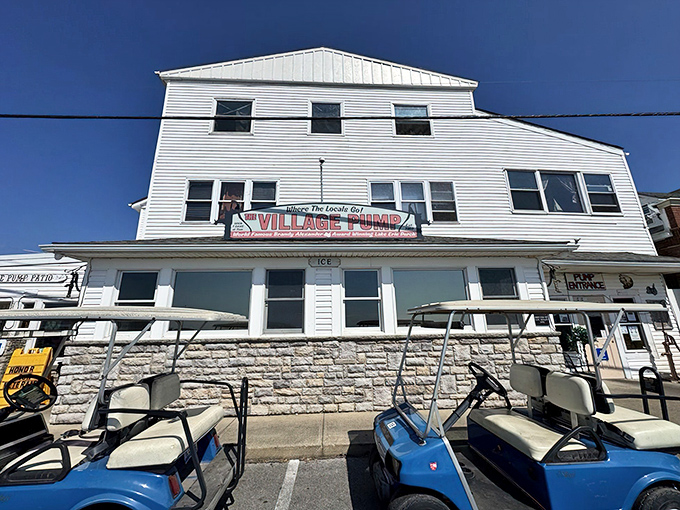 The white clapboard exterior of The Village Pump stands like a beacon of culinary promise, with golf carts patiently waiting for their owners to finish "just one more bite."