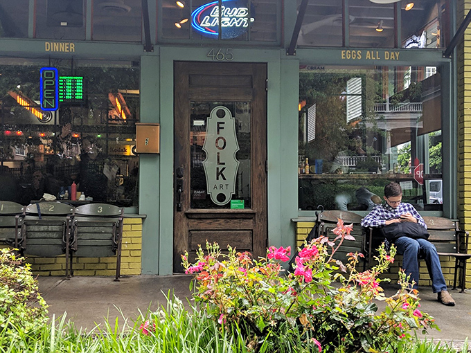 The teal and yellow exterior of Folk Art stands out like a culinary beacon, complete with a whimsical snail mural that seems to whisper, "Good things come to those who wait."