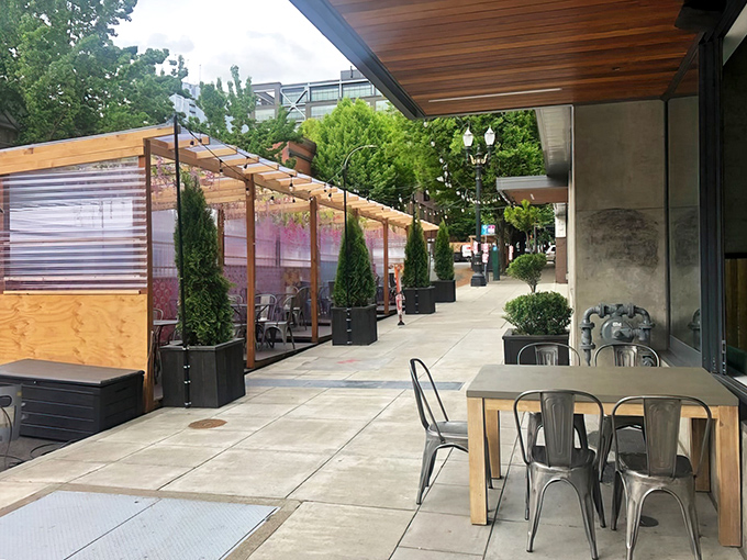 The outdoor dining area at Farmhouse Kitchen feels like a secret garden oasis in Portland's urban landscape, with thoughtfully placed greenery creating intimate dining nooks.