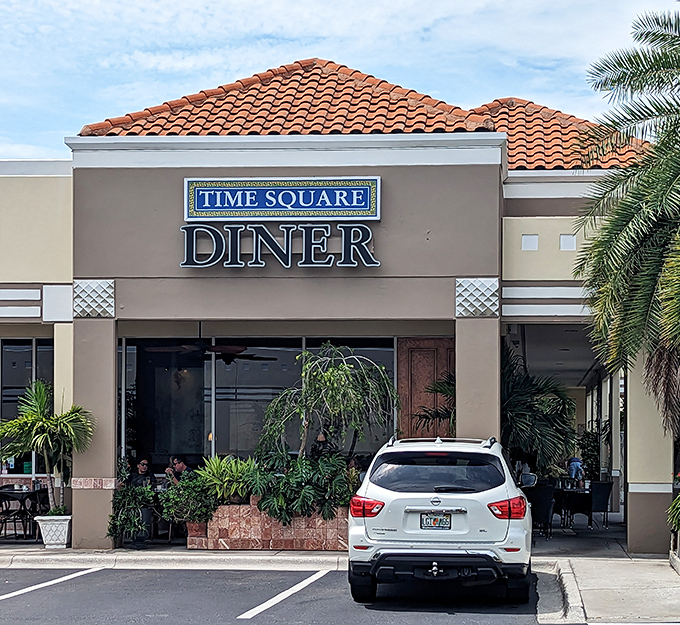 Palm trees frame the entrance to Time Square Diner like nature's own welcome committee, offering a shady respite from the Florida sun.