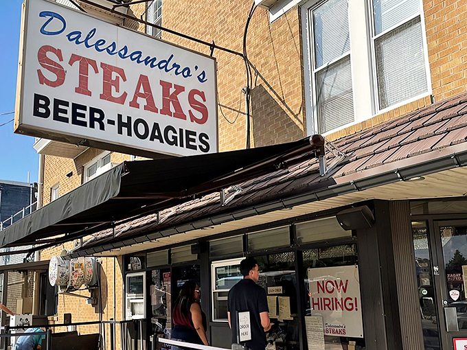 The iconic blue and red sign beckons sandwich pilgrims like a neon North Star. Philadelphia's cheesesteak heaven awaits inside these humble brick walls.