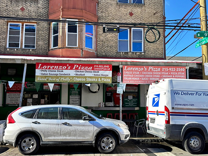 The iconic green exterior of Lorenzo's Pizza stands as a beacon of hope for the hungry at 9th and Christian in South Philly's Italian Market.