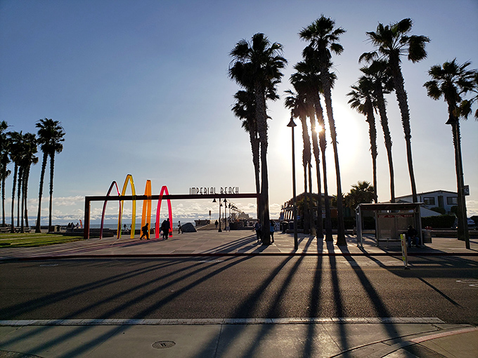 The setting sun casts long shadows across Imperial Beach, highlighting towering palms and the town&rsquo;s relaxed charm along the Pacific shore.