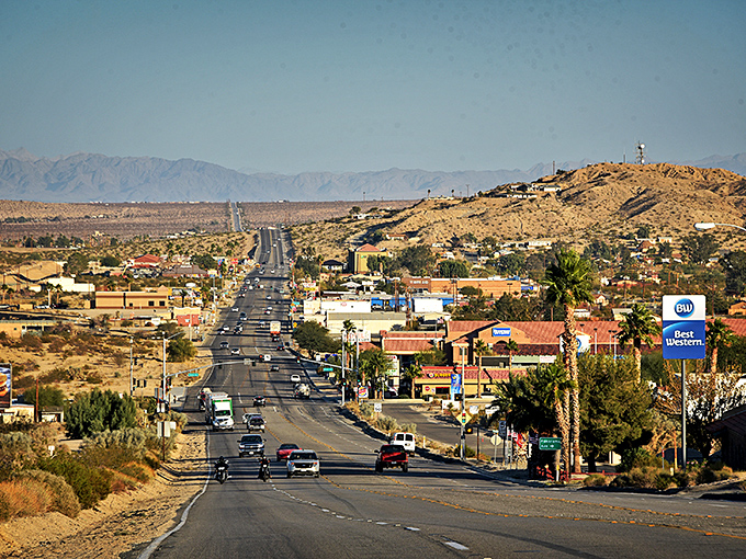 Highway 62 stretches toward the horizon like a promise, with mountains standing guard over this high desert haven for retirees seeking peace.