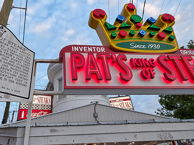 Glowing in neon since 1930, Pat’s has stood as Philly’s cheesesteak beacon, drawing generations of hungry pilgrims to its legendary window.