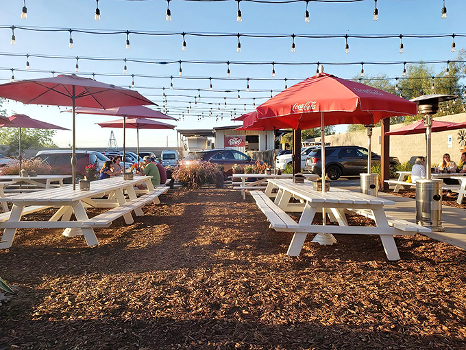 String lights hover like BBQ angels over white picnic tables, creating the perfect Arizona evening backdrop for meat-induced happiness.