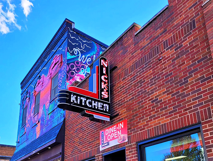 The iconic brick exterior of Nick's Kitchen, with its vintage neon sign promising culinary treasures within. Downtown Huntington's crown jewel beckons hungry travelers.