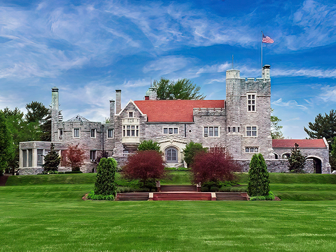 The castle's magnificent fa&ccedil;ade showcases its perfect symmetry, where gray stone meets red roof against an impossibly blue Ohio sky.