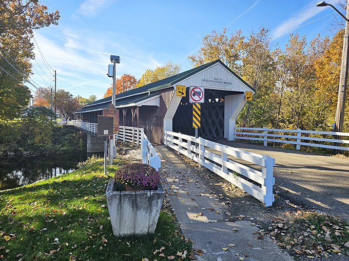 The Historic Newton Falls Covered Bridge stands like a time machine disguised as architecture, its white railings and green roof beckoning travelers into Ohio's past.