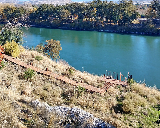 The Sacramento River flows past like a turquoise ribbon, unchanged since the days when pioneers first gazed upon these same waters.