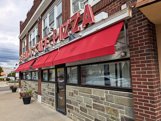 The iconic red awnings of Revello's Pizza Cafe stand out like a beacon for hungry travelers. This brick-faced institution has been satisfying Old Forge appetites for generations.