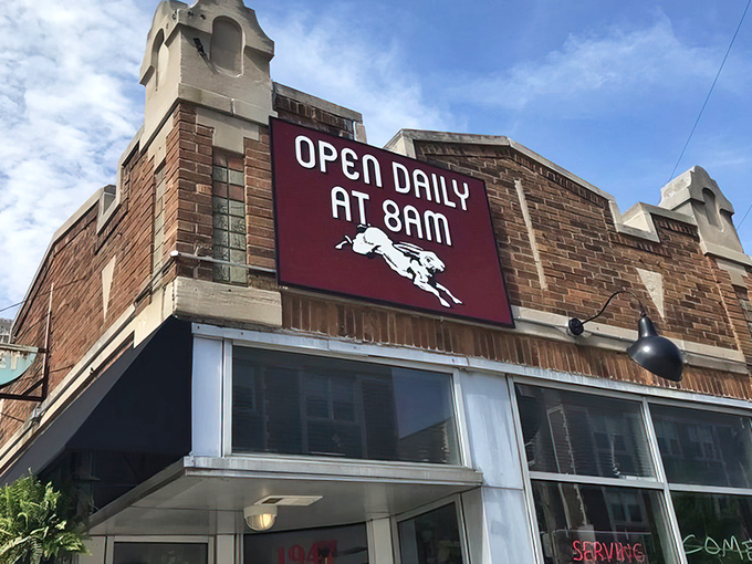 The inviting storefront of Comet Cafe beckons with its brick facade and lush planters. Milwaukee's East Side gem awaits your discovery.