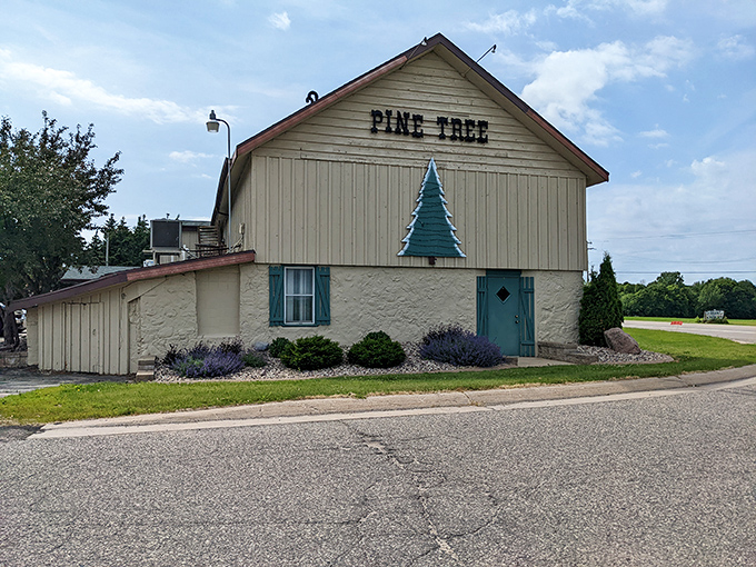 The unassuming exterior of Pine Tree Supper Club stands like a culinary lighthouse in New London, its iconic green tree emblem promising Midwest comfort within.