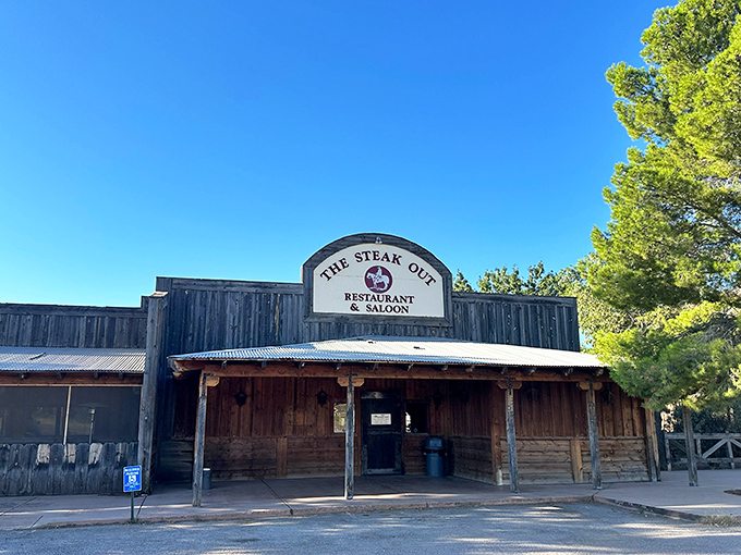 The weathered wooden facade of The Steak Out stands proudly against Arizona's brilliant blue sky, like a movie set waiting for its cowboy stars.