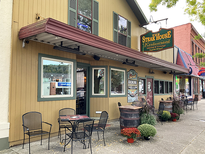 The charming exterior of The Steak House beckons hungry travelers with its classic awning and inviting outdoor seating&mdash;a Main Street fixture that promises culinary comfort.