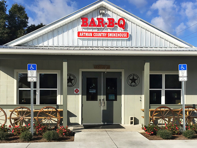 The unassuming exterior of Artman Country Smokehouse beckons with rustic charm. Those wagon wheels aren't just decoration&mdash;they're a promise of old-fashioned barbecue goodness waiting inside.