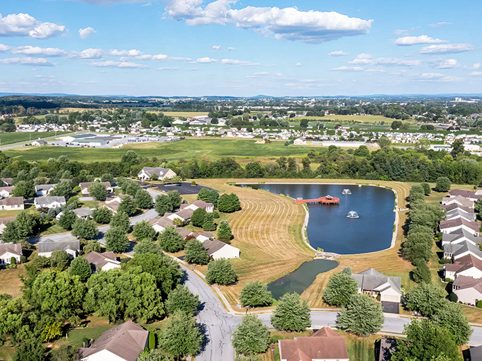 Aerial dreams come true! Arbor Gate's perfectly arranged homes surround a glistening pond, like a retirement community designed by someone who actually understands what "golden years" should mean