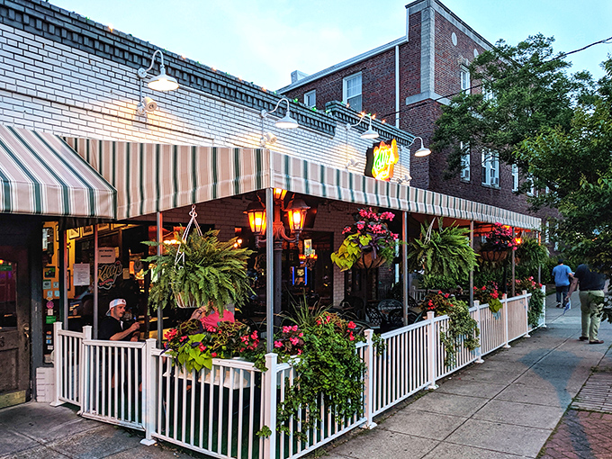 Kelly's Tavern's charming brick exterior with striped awnings and lush hanging plants creates an inviting oasis in Norfolk's urban landscape.