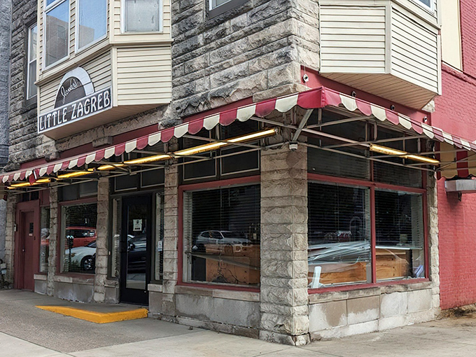 The iconic red and white awning of Little Zagreb beckons like a culinary lighthouse on Bloomington's 6th Street, promising meaty treasures within.
