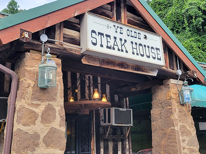 The iconic green awning and rustic log cabin exterior of Ye Olde Steak House stands as a beacon for carnivores seeking refuge from the ordinary.
