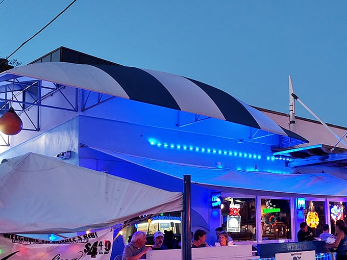 The blue facade of The Whale's Rib stands as a beacon of seafood salvation, where flags flutter in the ocean breeze and hungry patrons find their way home.