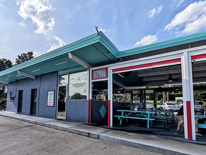Blue skies frame this slice of Americana where generations have gathered for post-game celebrations and first dates. The architecture alone tells you you're in for something special.