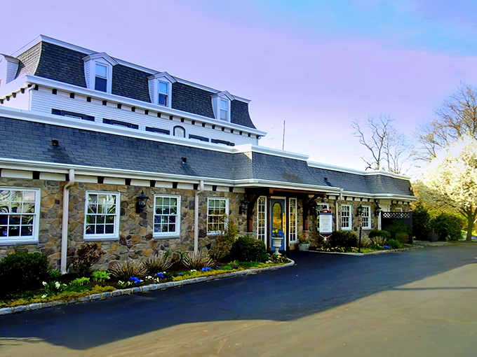 The historic stone fa&ccedil;ade of Spring House Tavern glows at dusk, its distinctive mansard roof and warm lighting promising culinary comfort within.
