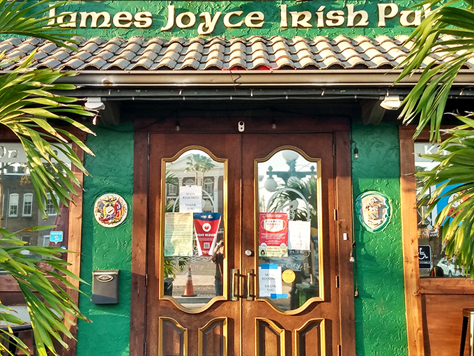 The emerald facade of James Joyce Irish Pub welcomes visitors with wooden doors and palm fronds&mdash;Ireland meets Florida in this cultural crossroads.