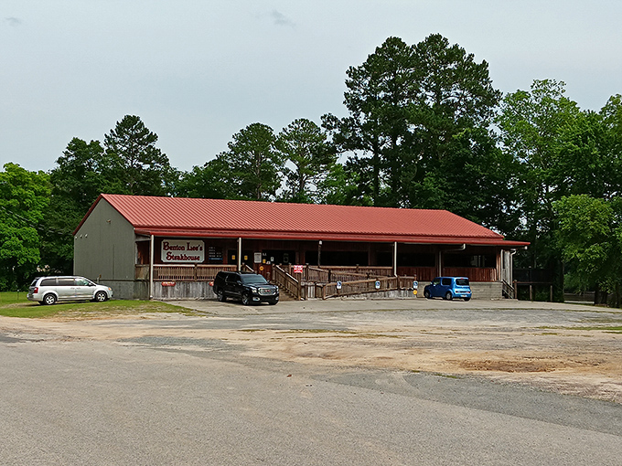 A wider view reveals Benton Lee's rustic charm nestled among Georgia pines &ndash; where pickup trucks in the parking lot tell the real story.