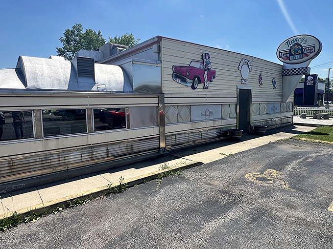 The classic silver diner car gleams in the Ohio sunshine, a time capsule of Americana complete with vintage car artwork that promises good eats inside.