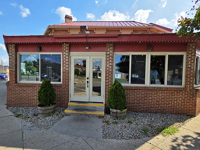 Two neatly trimmed shrubs stand guard at the entrance, like culinary bouncers ensuring only the worthy experience what lies beyond those doors.