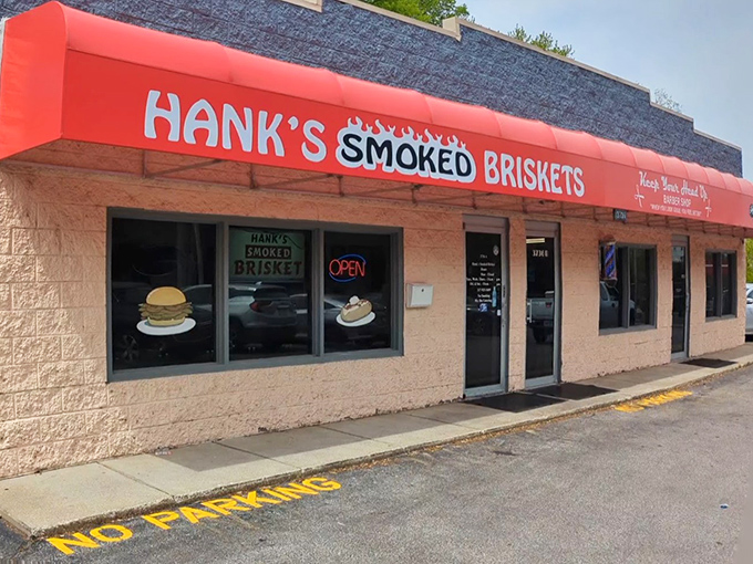 The iconic red awning of Hank's Smoked Briskets stands out like a beacon for BBQ pilgrims. Those neon "OPEN" signs might as well say "HEAVEN."