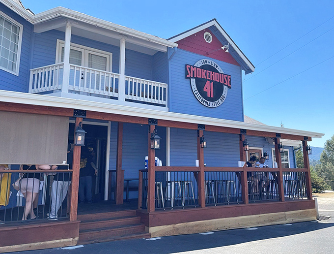 The blue beacon of barbecue heaven! Smokehouse 41's charming exterior promises smoky delights with its wrap-around porch and mountain backdrop.