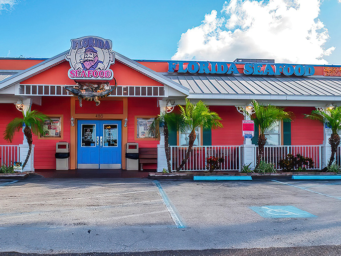 The coral-pink exterior glows like a neon-lit treasure chest at night, beckoning hungry seafood lovers with its maritime charm and promise of oceanic delights.
