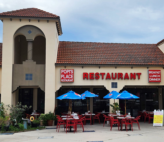 The welcoming facade of Popi's Place in Bradenton, where those cheerful red chairs practically beg you to sit down and stay awhile.