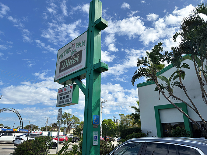 The iconic green and white sign of Peter Pan Diner stands tall against Florida's blue sky, beckoning hungry travelers like a culinary lighthouse in Oakland Park.
