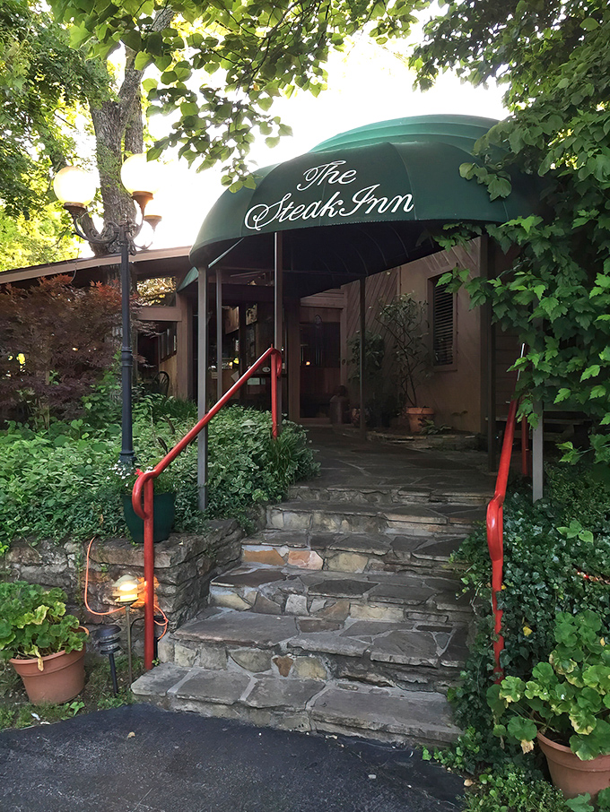 The entrance to culinary paradise isn't always flashy. Stone steps, lush greenery, and that iconic green awning welcome you to Shell Knob's worst-kept secret.