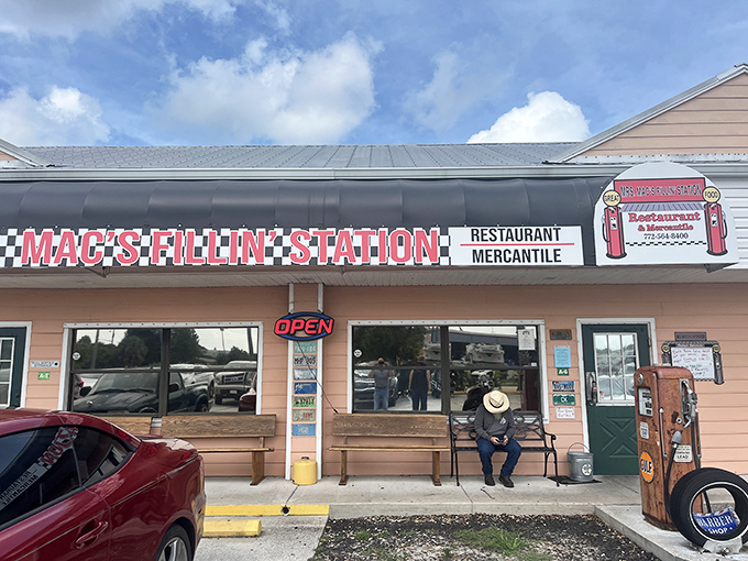 The pink facade of Mrs. Mac's Fillin' Station welcomes hungry travelers with its vintage gas station theme and promise of comfort food ahead.