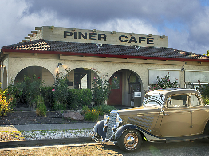 The unassuming exterior of Piner Cafe, with its stucco walls and vintage car out front, promises authentic diner magic without the fanfare.
