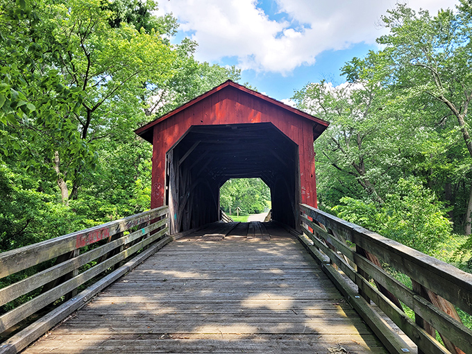 The classic red siding of Sugar Creek Covered Bridge pops against Illinois greenery like a Norman Rockwell painting come to life.