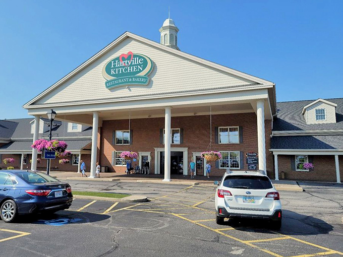 The welcoming facade of Hartville Kitchen stands proudly with its white columns and hanging flower baskets, like a culinary embassy of comfort food.