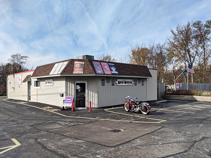 The outdoor patio at The Red Onion offers a perfect summer escape with wooden picnic tables, striped umbrellas, and that essential American flag waving in the Ohio breeze.