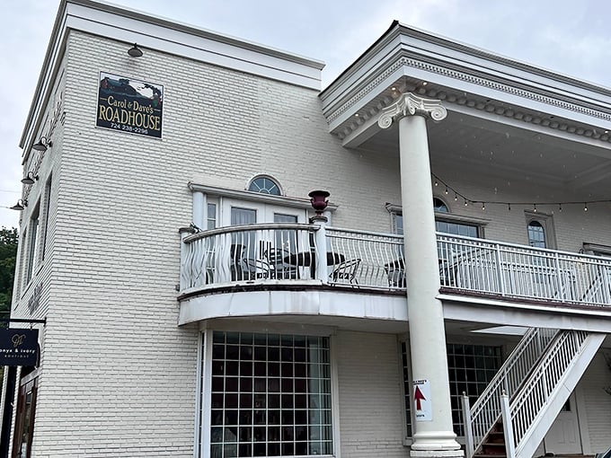 The stately white brick exterior of Carol & Dave's Roadhouse stands like a culinary lighthouse in Ligonier, beckoning hungry travelers with its classic columns and inviting balcony.